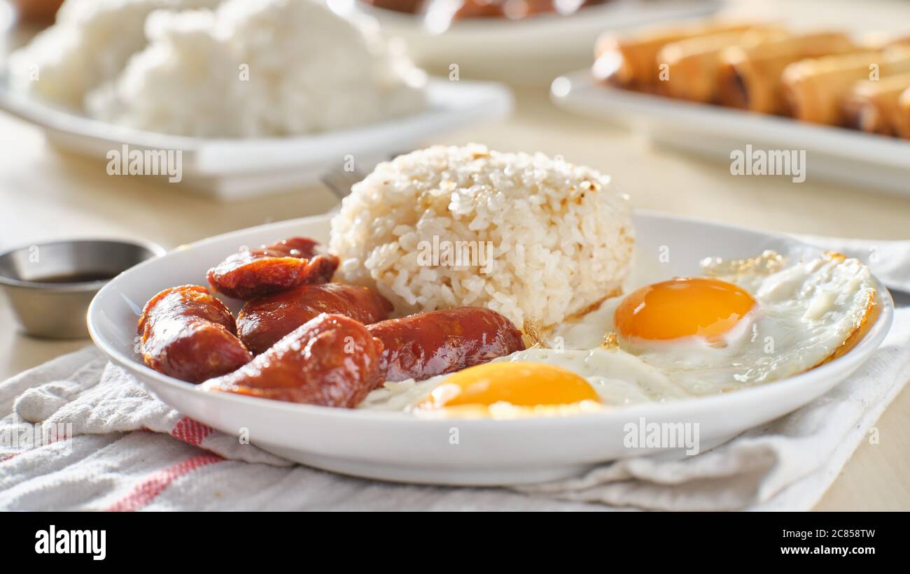 filipino silog breakfast with garlic fried rice, longsilog, and two sunny side up eggs Stock ...