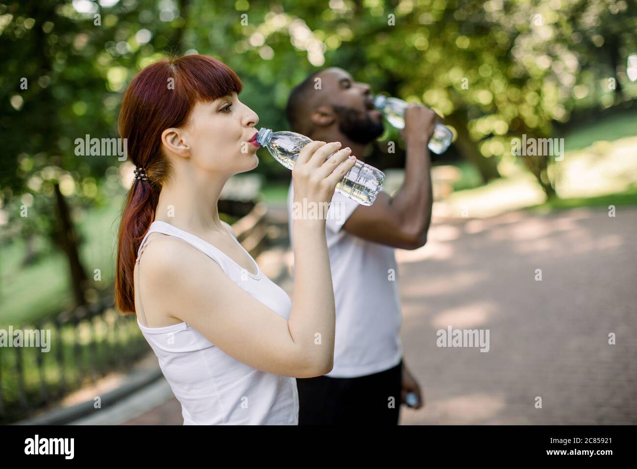 Water break, sport and fitness concept. Happy young multiethnic friends ...