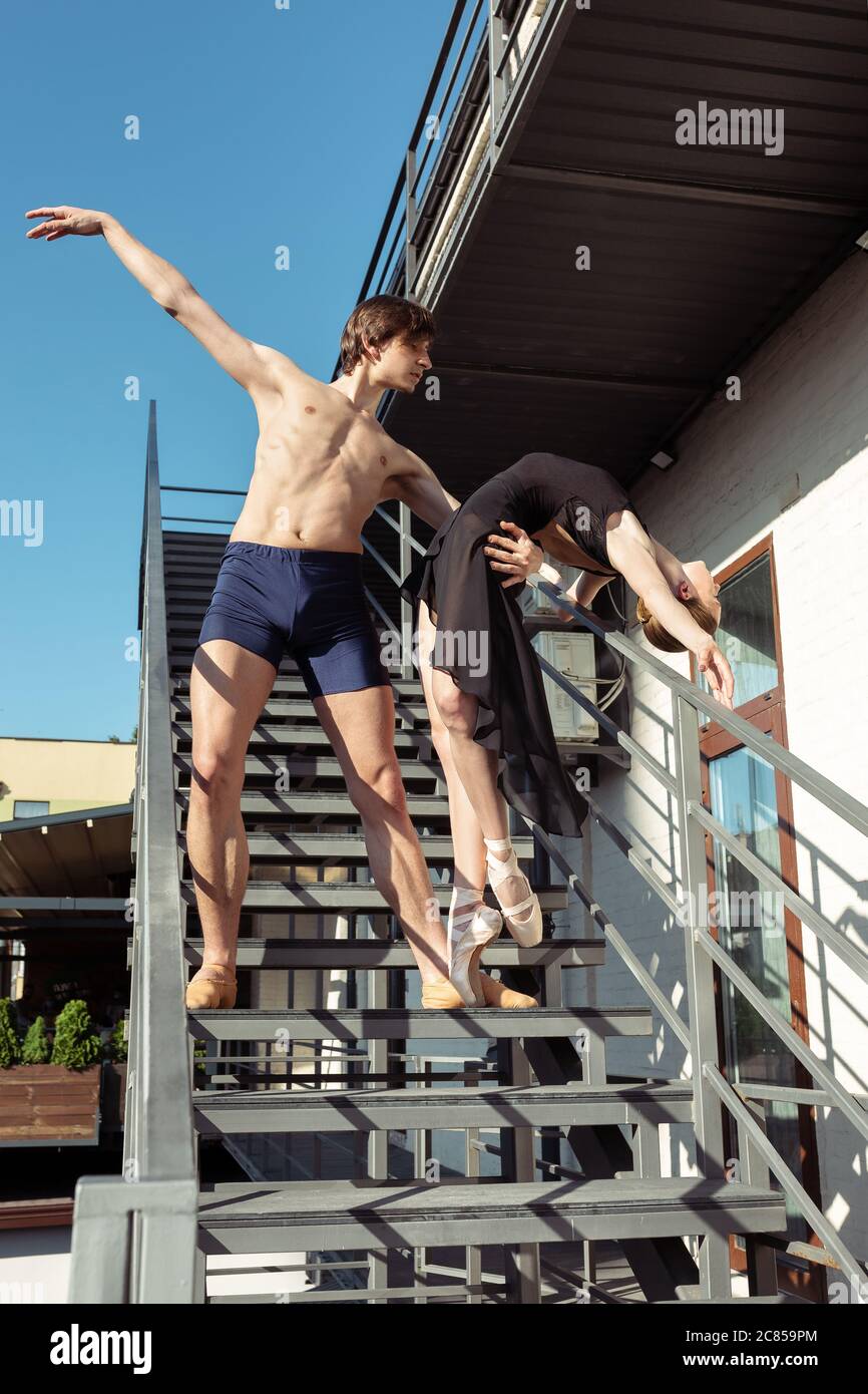 Couple of modern ballet dancers performing on the stairs at the city ...