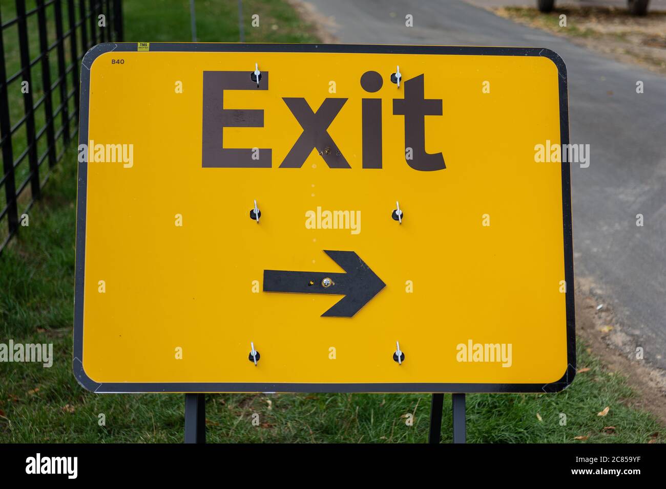 A yellow traffic sign informs drivers and pedestrians which way to head ...