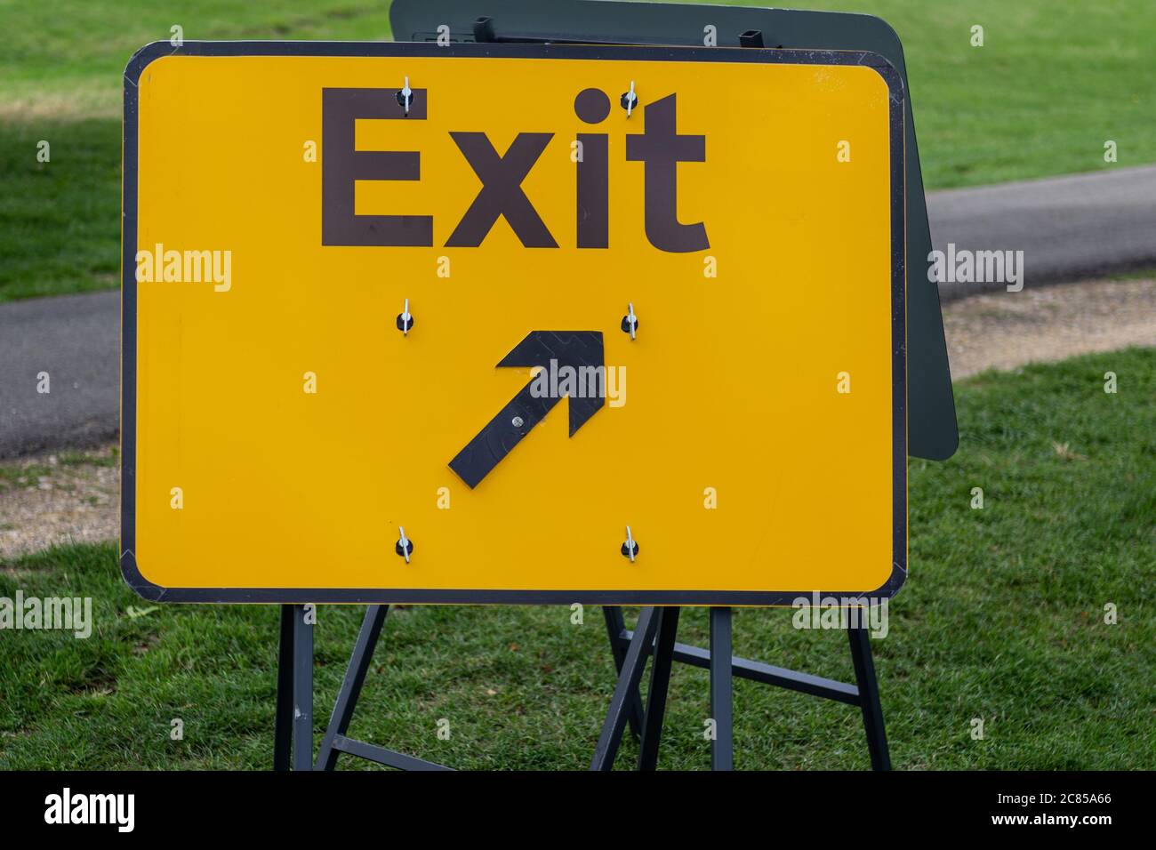 A yellow traffic sign informs drivers and pedestrians which way to head ...