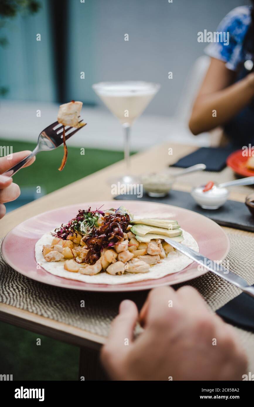 Person eating a dish with chicken, cabbage and avocados Stock Photo - Alamy