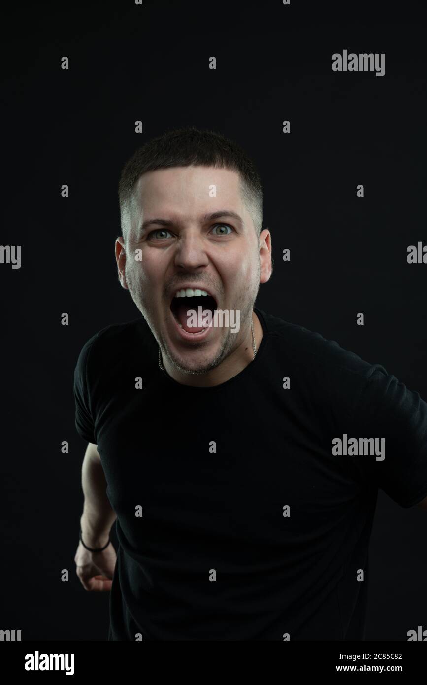 Portrait of young aggressive male isolated over black background Stock ...