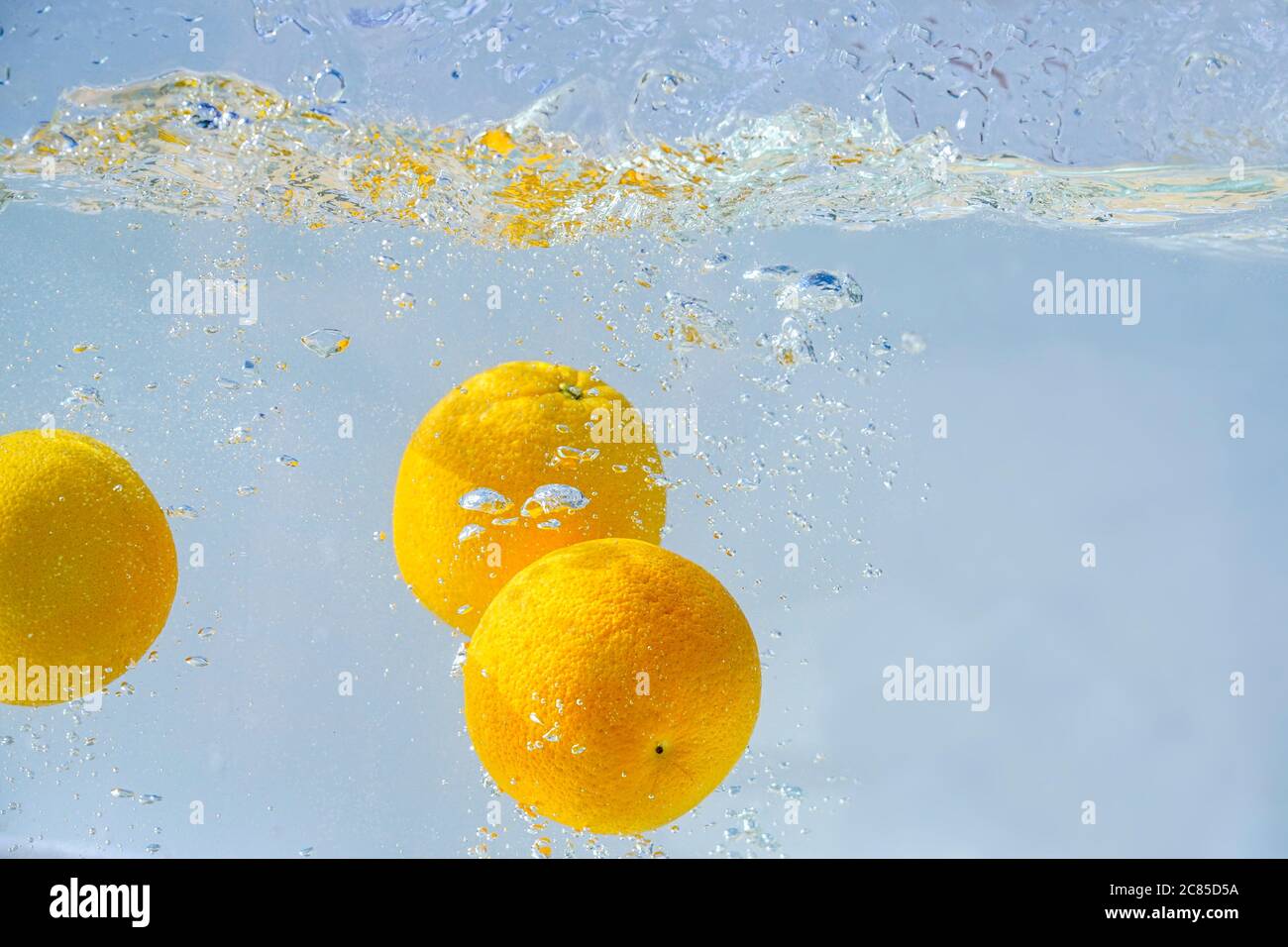 oranges fall into the water with bubbles Stock Photo - Alamy