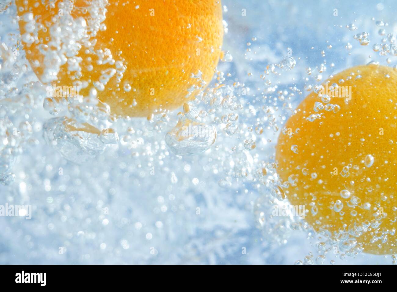 oranges fall into the water with bubbles Stock Photo - Alamy