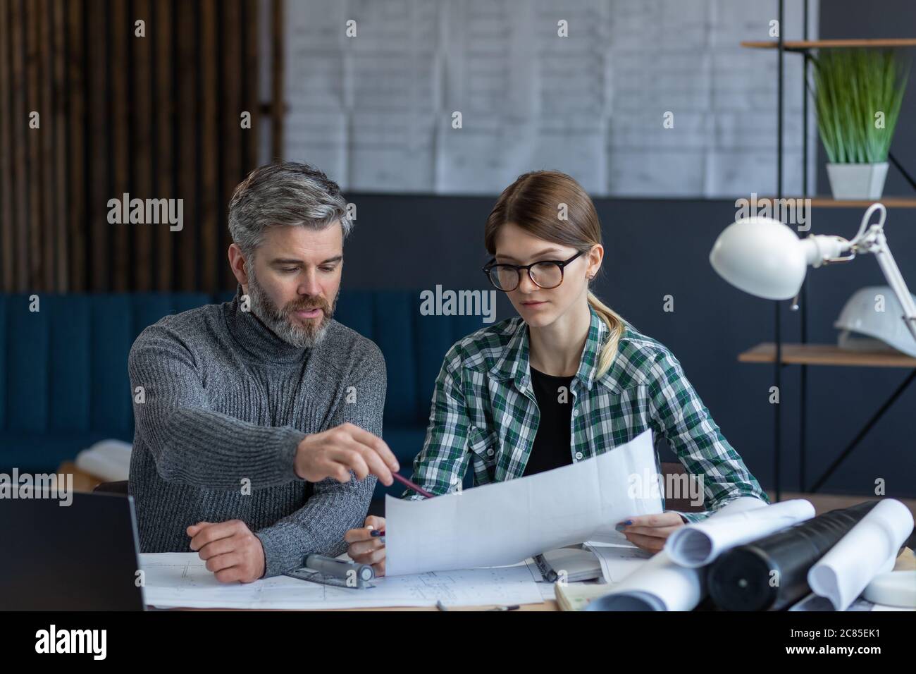 Interior designers team working in office with blueprints and architect ...