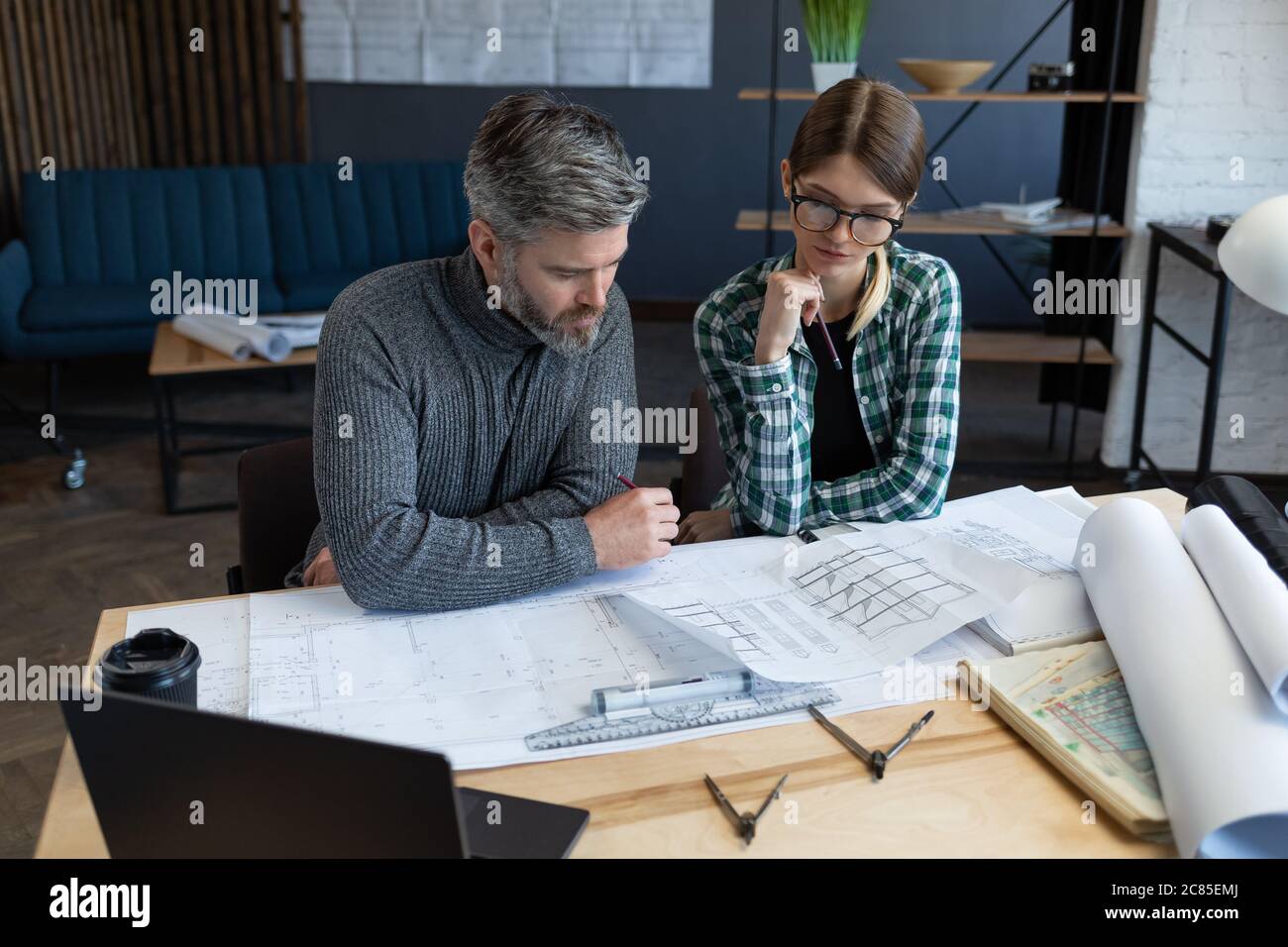 Interior designers team working in office with blueprints and architect ...