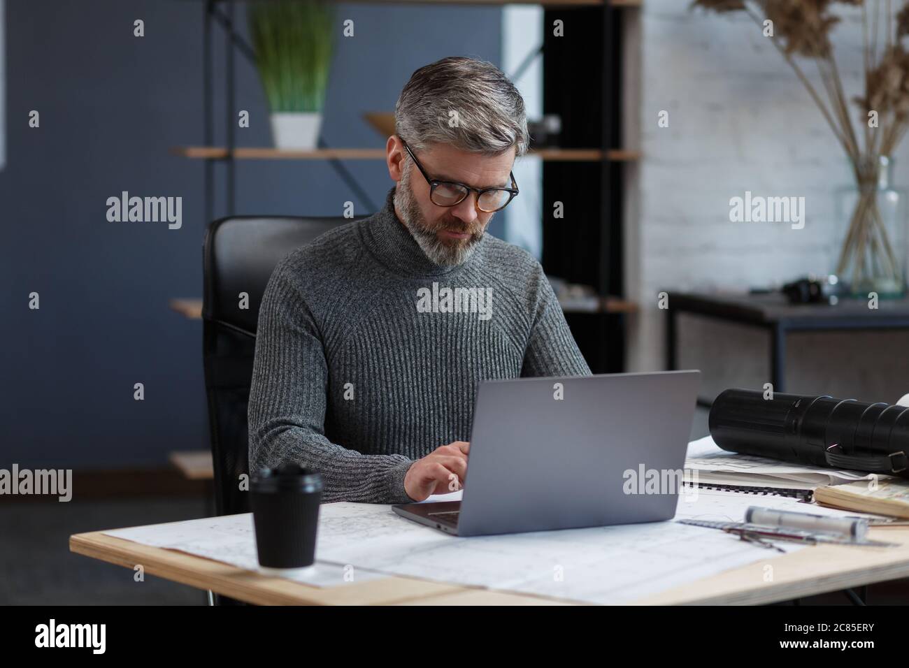 Designer working in office with laptop. Architect thinks over ...