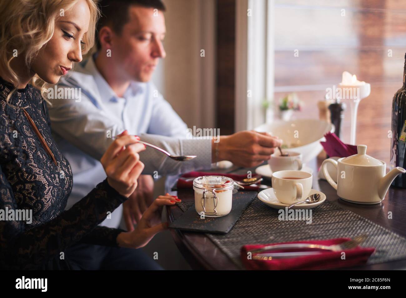Happy young couple eating pastries in a pastry shop Stock Photo - Alamy