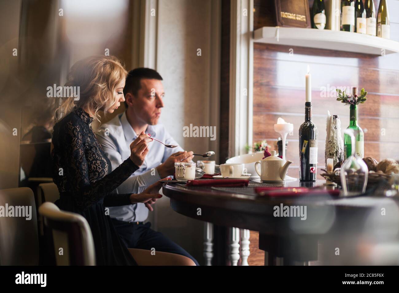 Happy young couple eating pastries in a pastry shop Stock Photo - Alamy