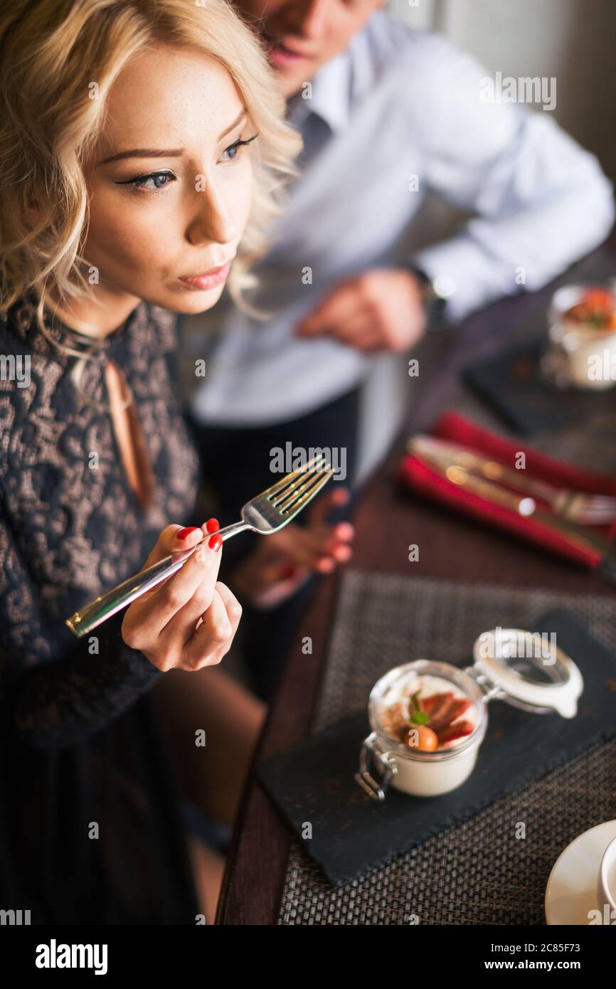 Happy young couple eating pastries in a pastry shop Stock Photo - Alamy