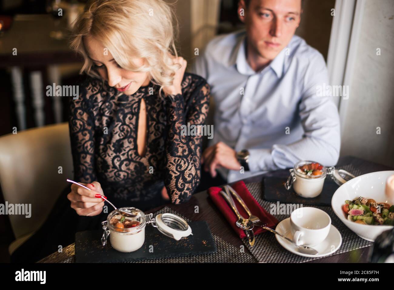 Happy young couple eating pastries in a pastry shop Stock Photo - Alamy
