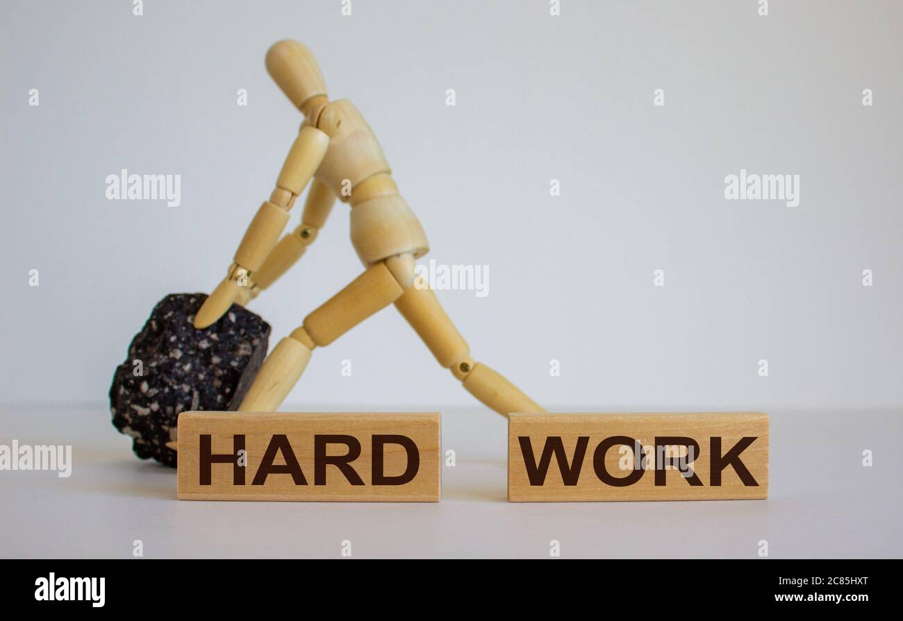 Wooden blocks with words 'hard work'. Wooden model of human with black ...