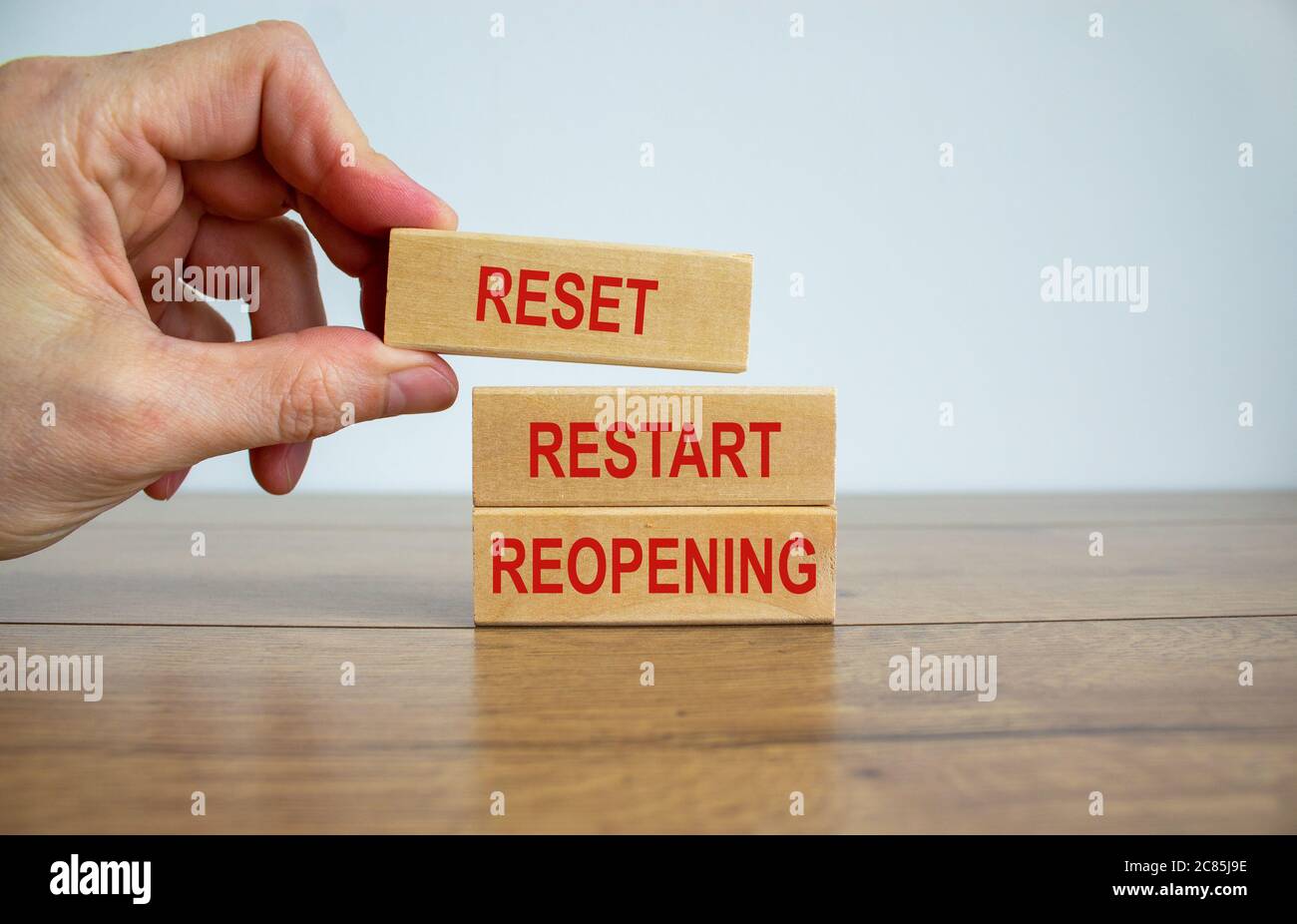 Male hand placing a blocks with word 'reset' on top of a blocks tower ...