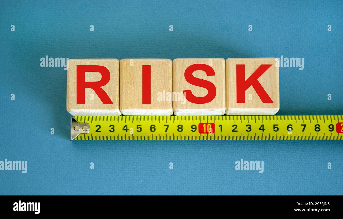 'Risk' word on cubes arranged behind the ruler on beautiful blue ...