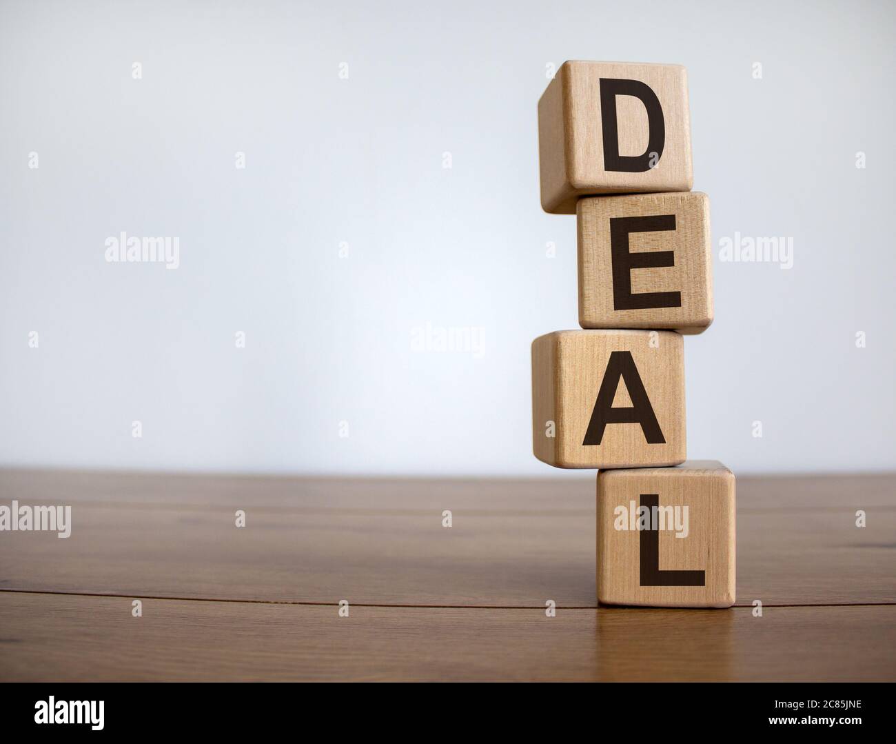Concept word 'deal' on cubes on a beautiful wooden table. White ...
