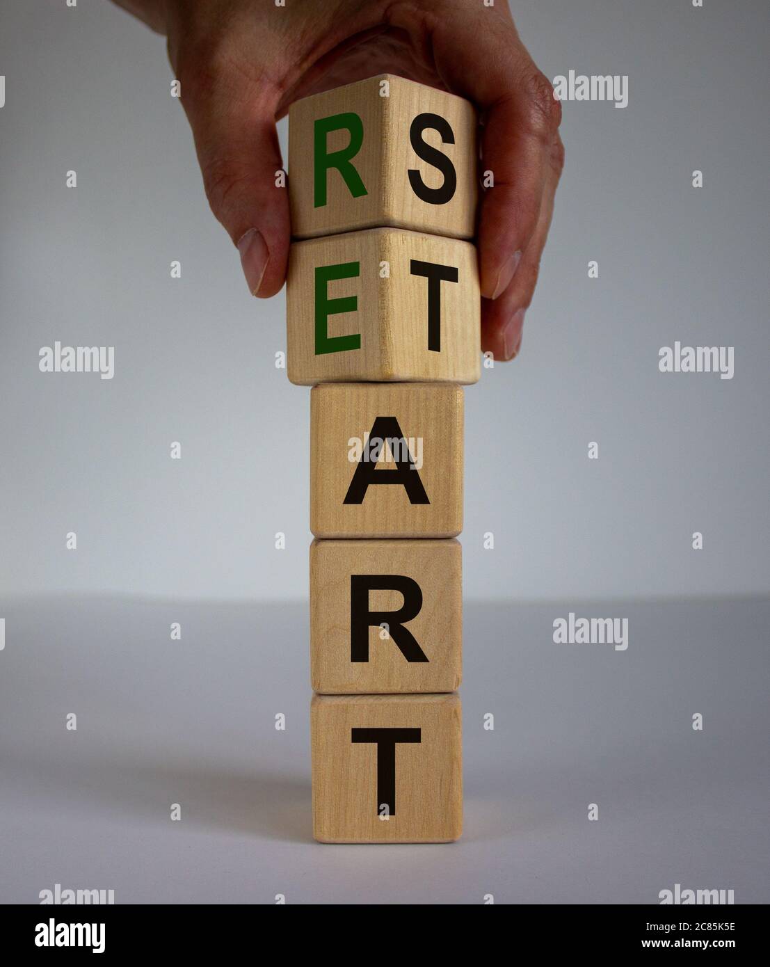 Concept word 'restart' on cubes on a beautiful wooden table. Male hand ...