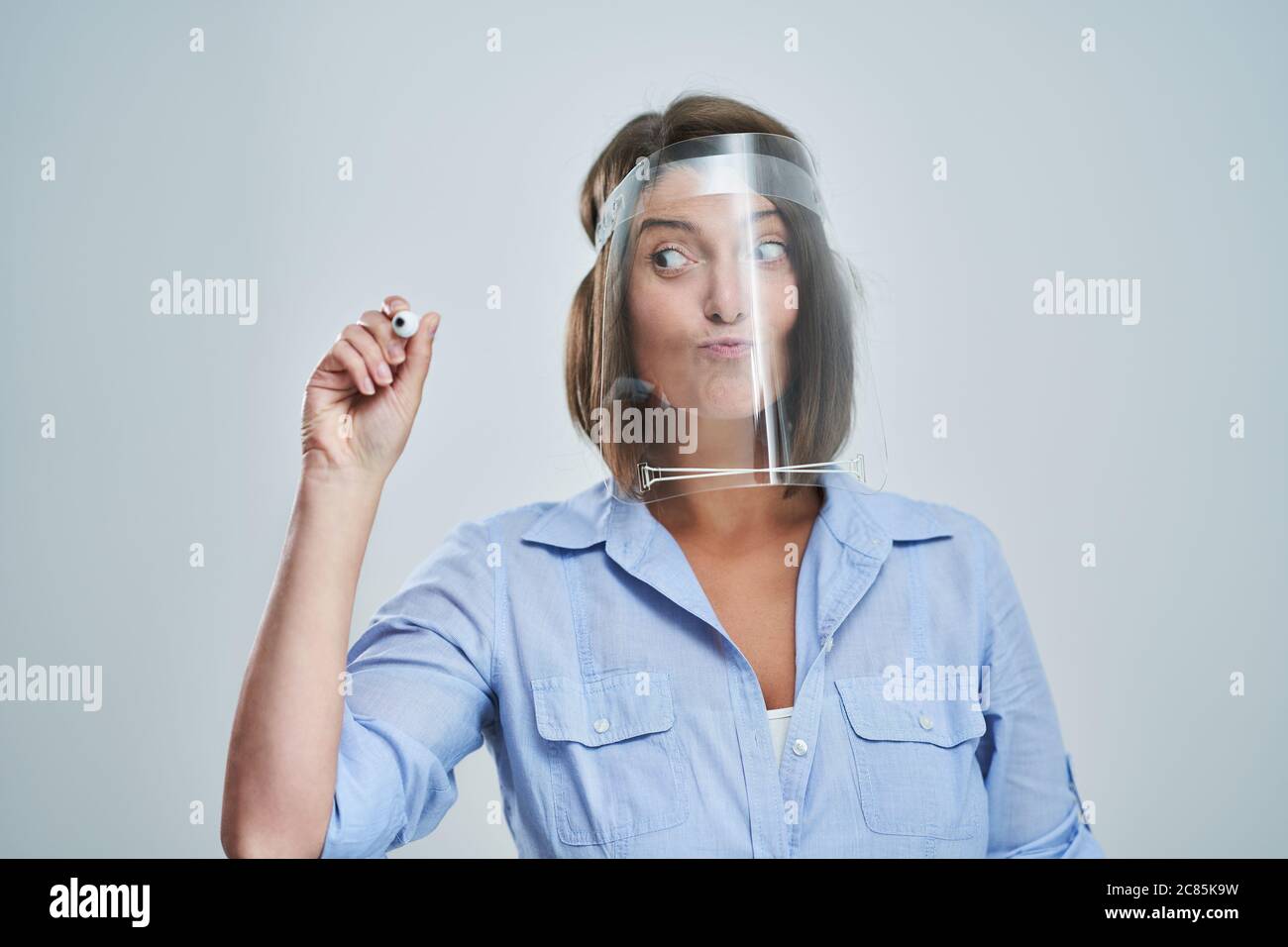 Attractive woman wearing protective shield writing over white ...