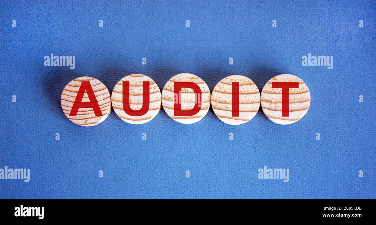 The word 'audit' on wooden circles on blue table. Beautiful background ...