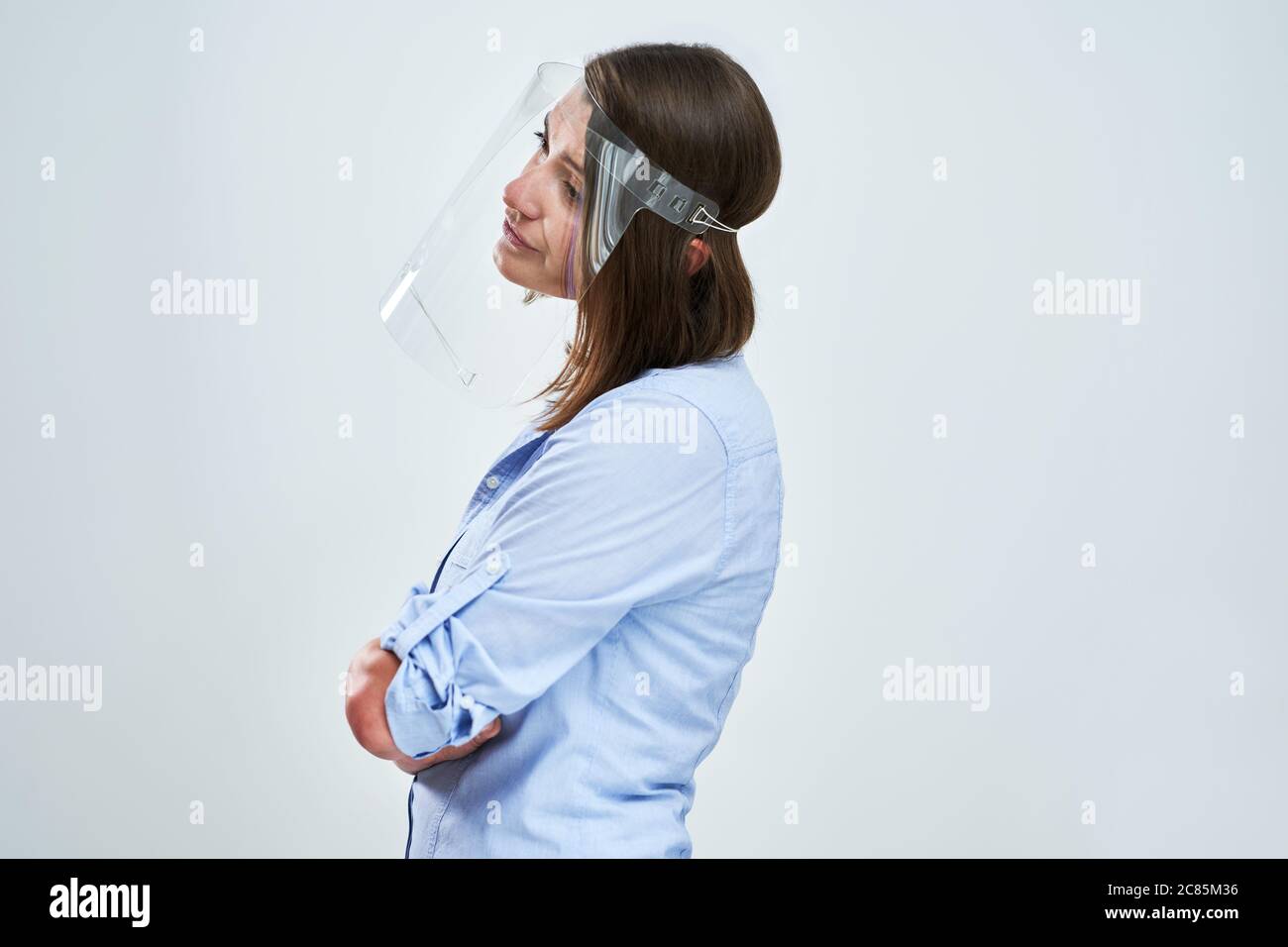 Attractive woman wearing protective shield thinking over white ...
