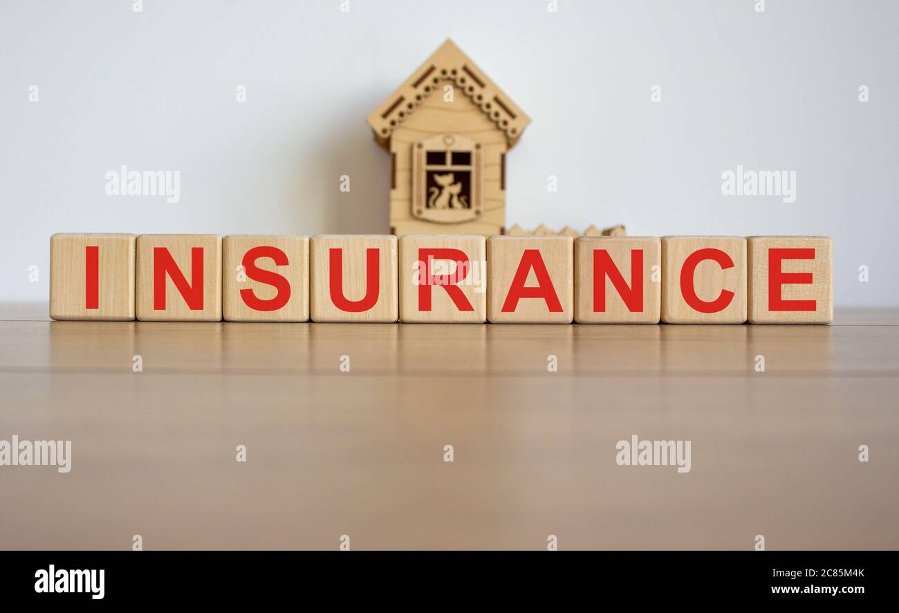 Cubes form the word insurance in front of a miniature house Stock Photo ...