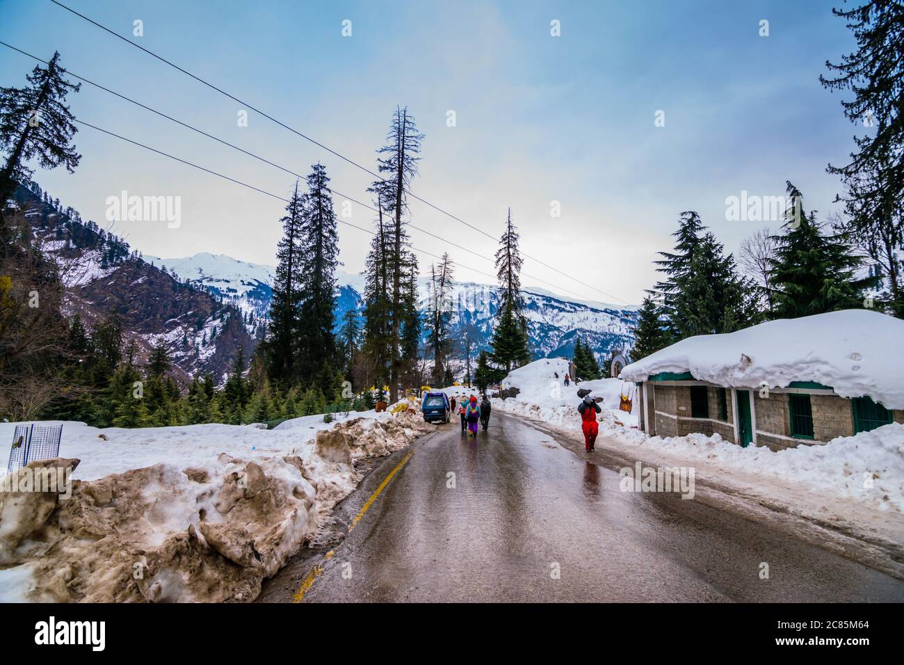 A landscape of a hilly highway after rain with snow capped houses by ...