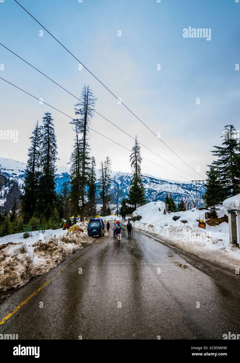 A landscape of a hilly highway after rain with snow capped houses by ...