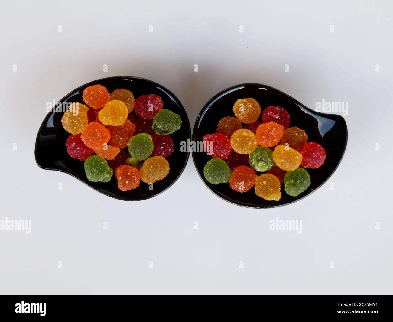 Sweet mixed color jelly candy in a black bowl against white background ...