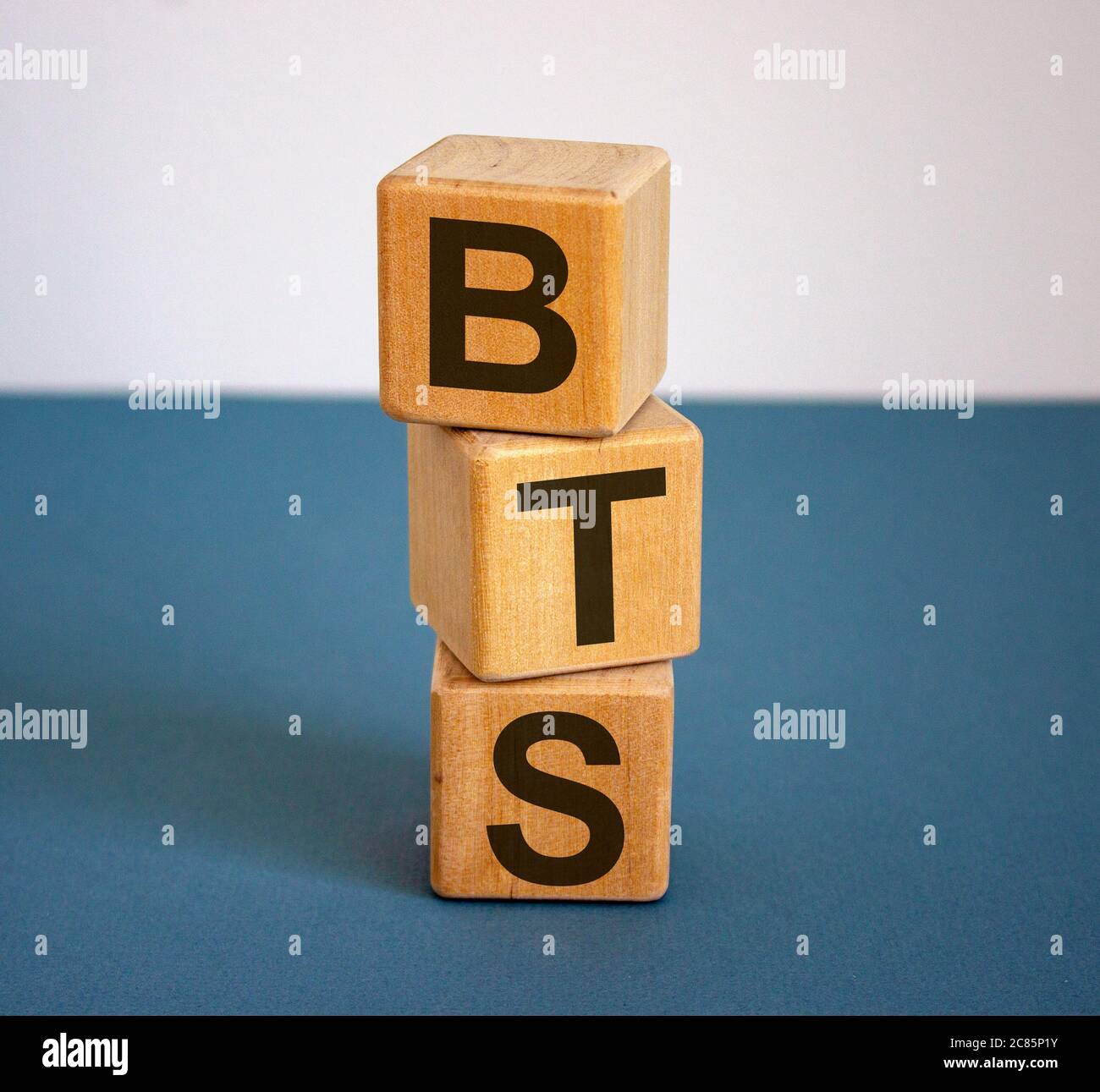 Wooden cubes with the inscription 'BTS'. Beautiful blue table and white ...