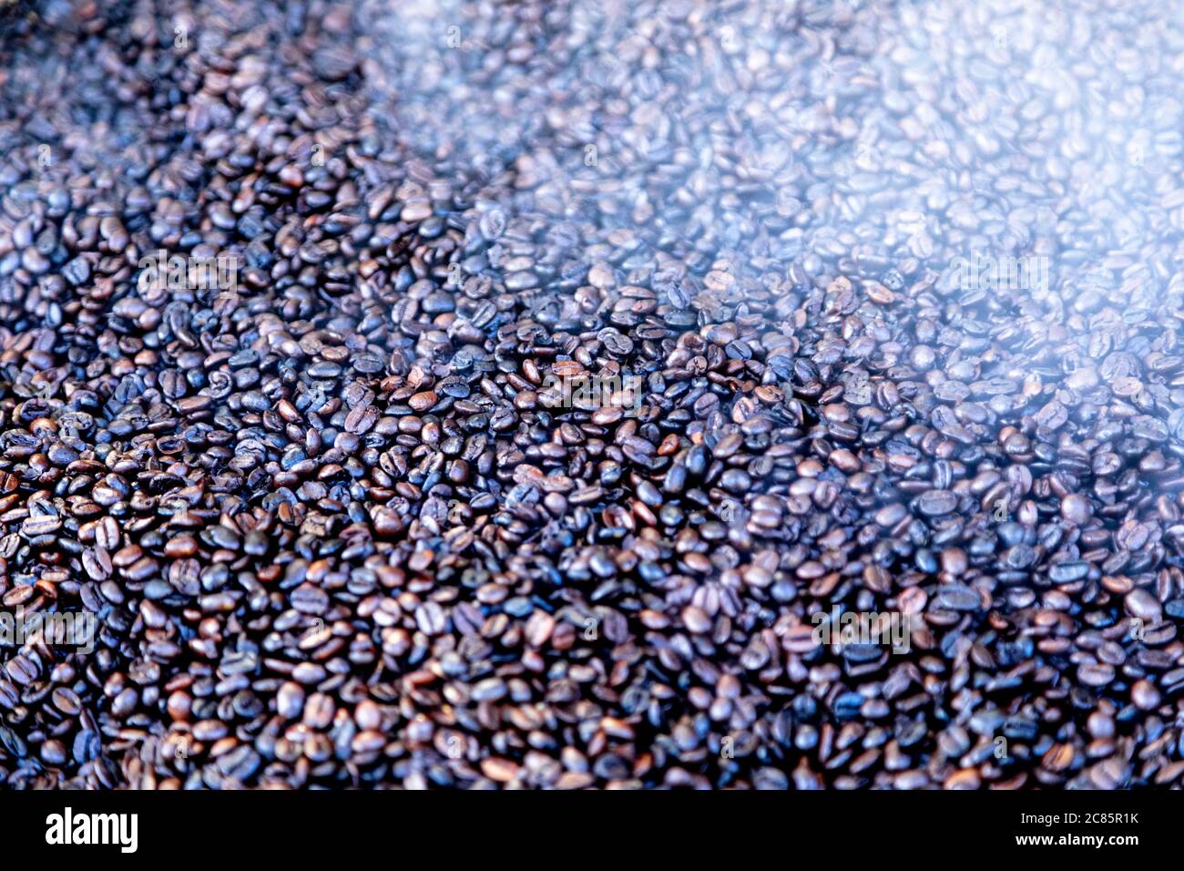 Roasted coffee beans, just came out of the fire, hot, smoke coming out ...