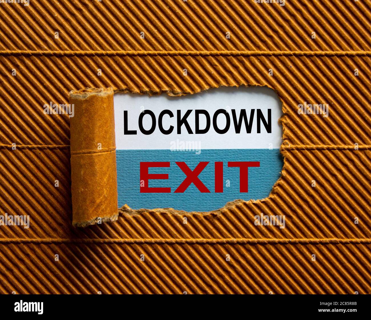 The text 'lockdown exit' appearing behind torn brown paper. Business ...