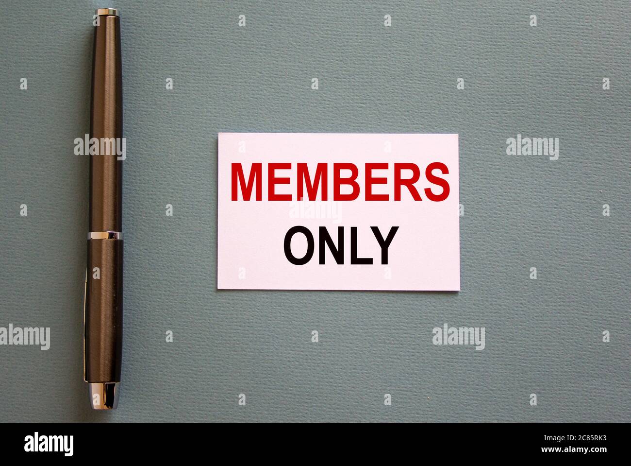 Pen and white card with words 'members only' on blue background ...