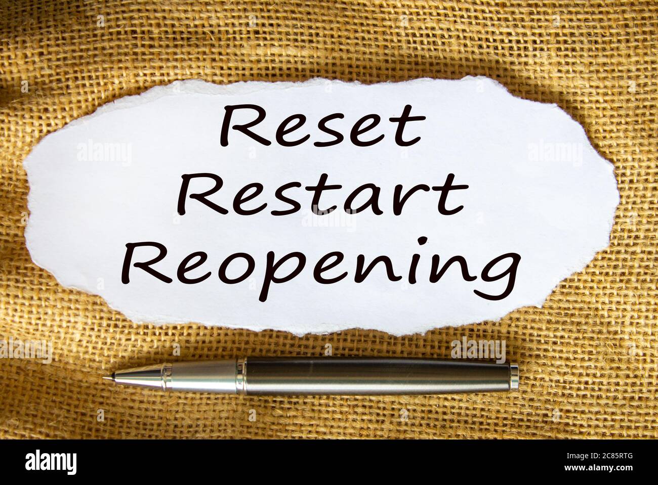 The text 'reset, restart, reopening' on white paper. Metalic pen ...