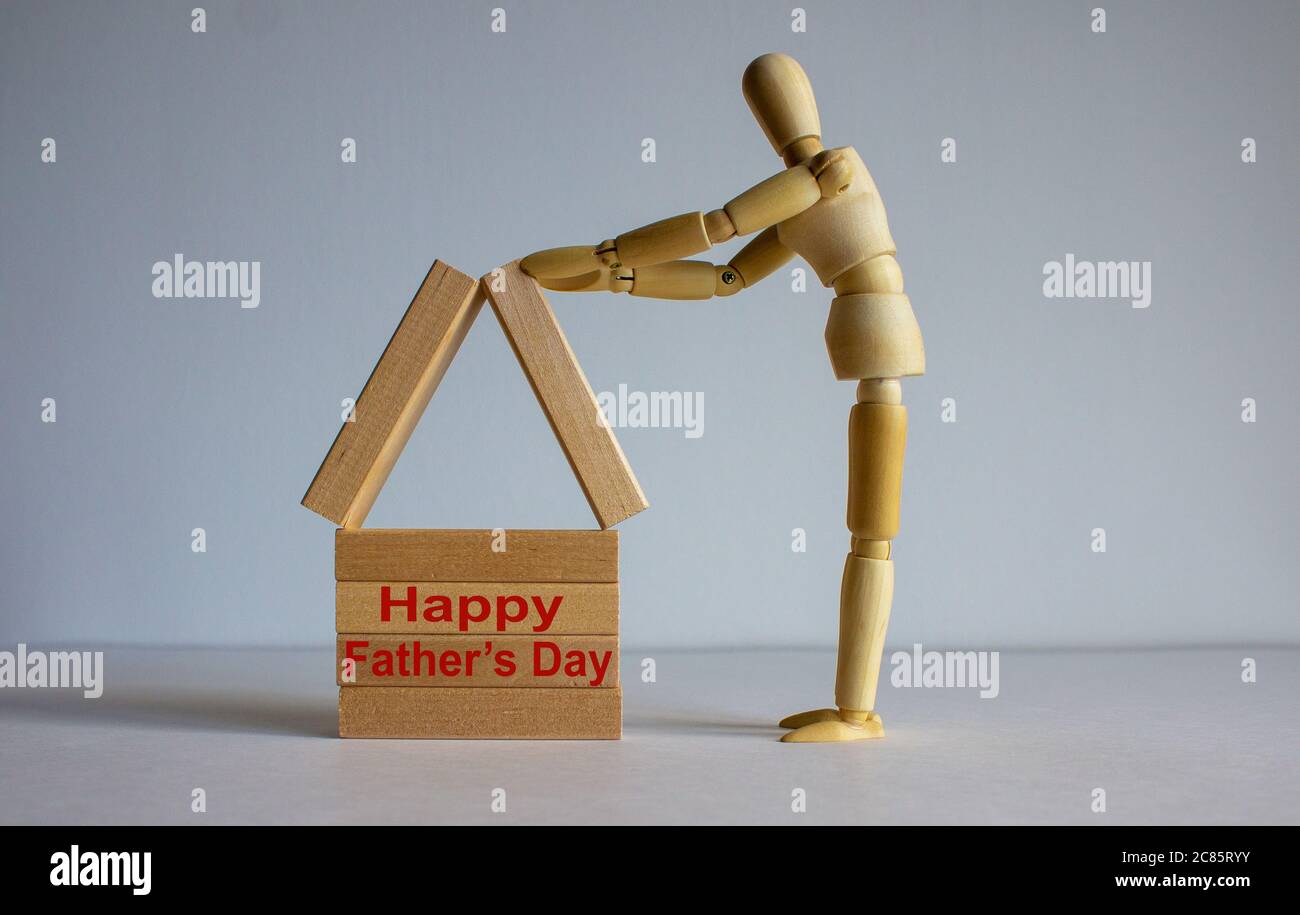 Wooden man builds a model of a wooden house. Lettering 'Happy Father's ...