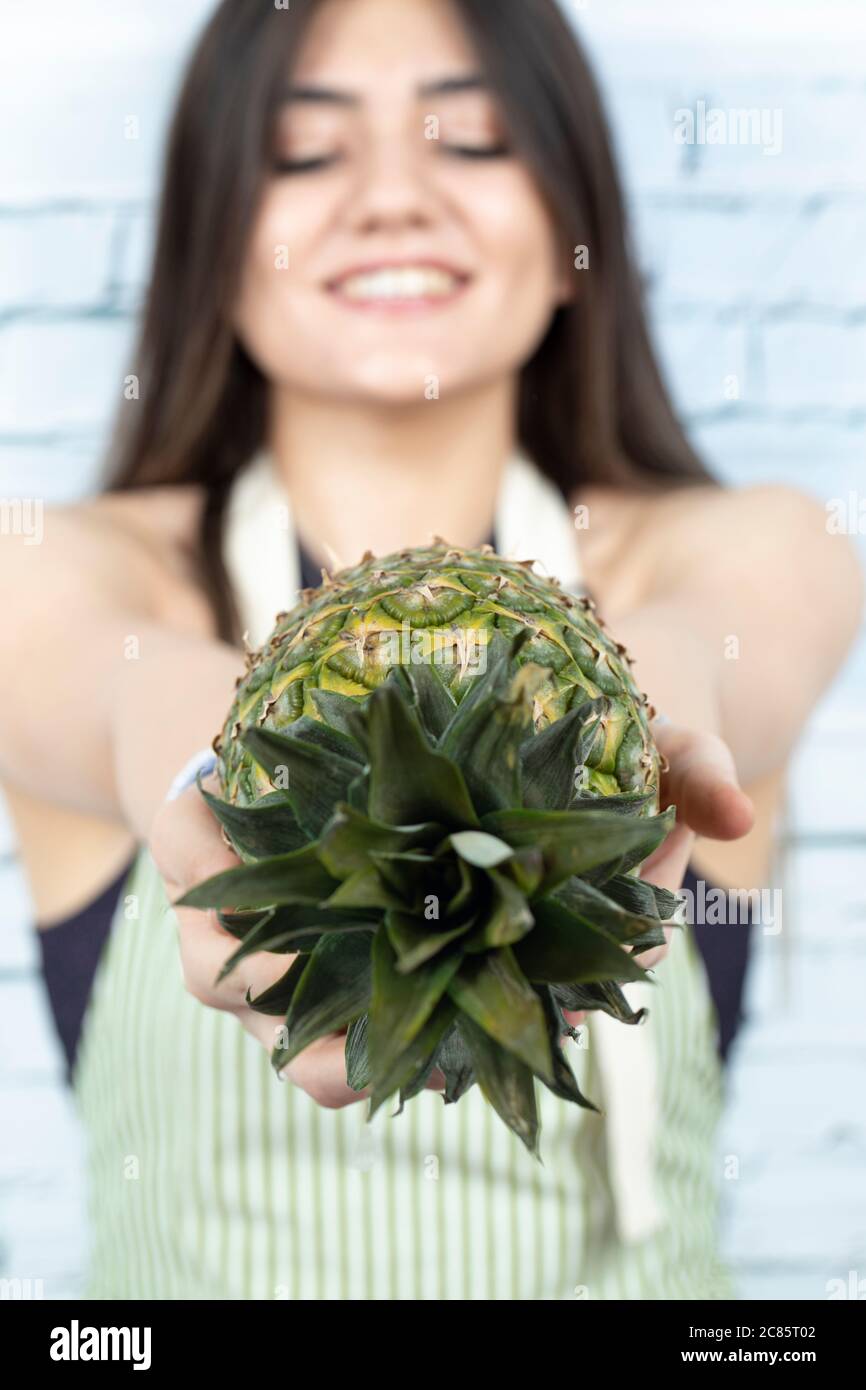Female chef holding a pineapple in hands Stock Photo - Alamy