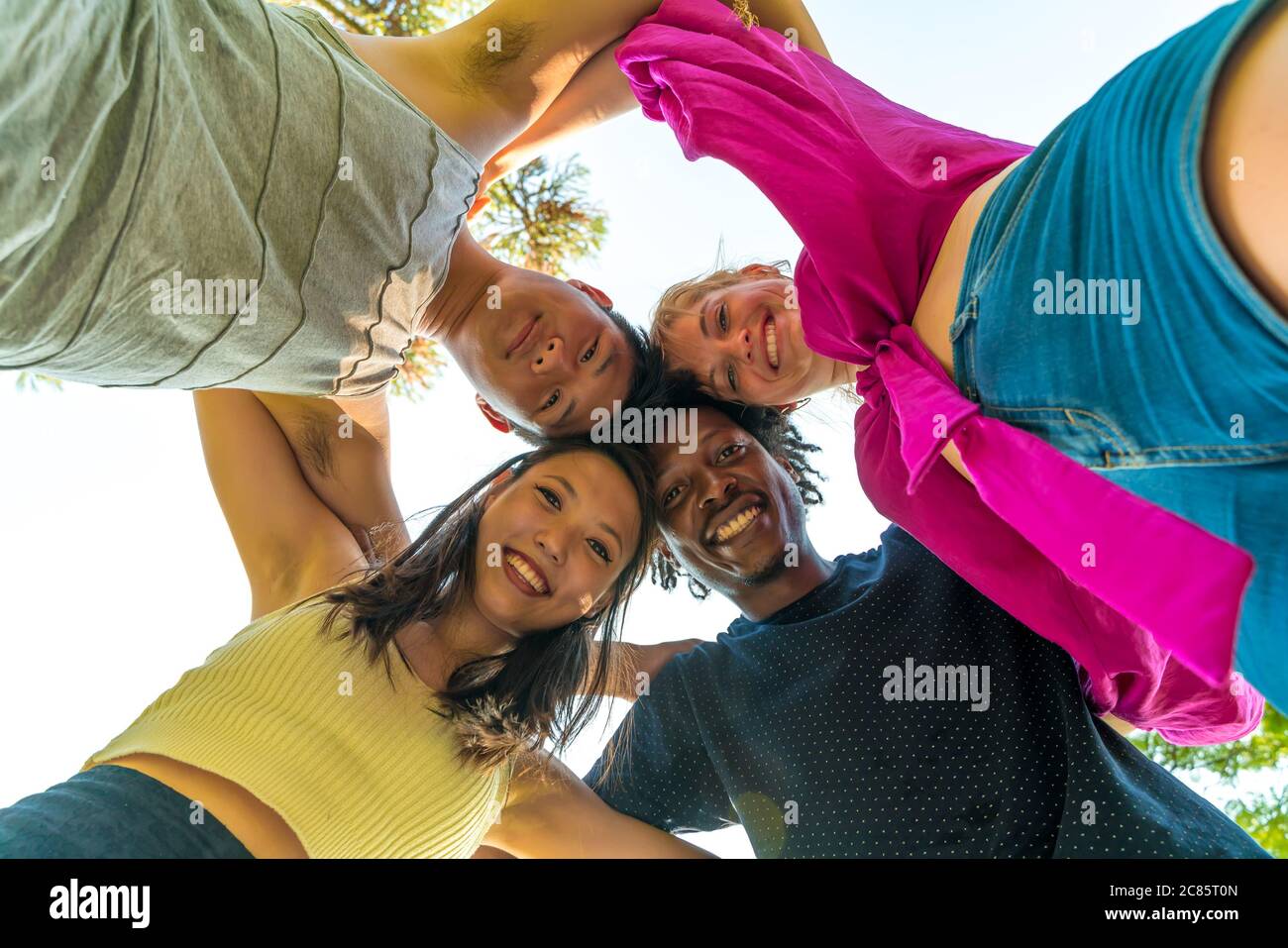 A group of friends or a team sticking their heads together Stock Photo ...