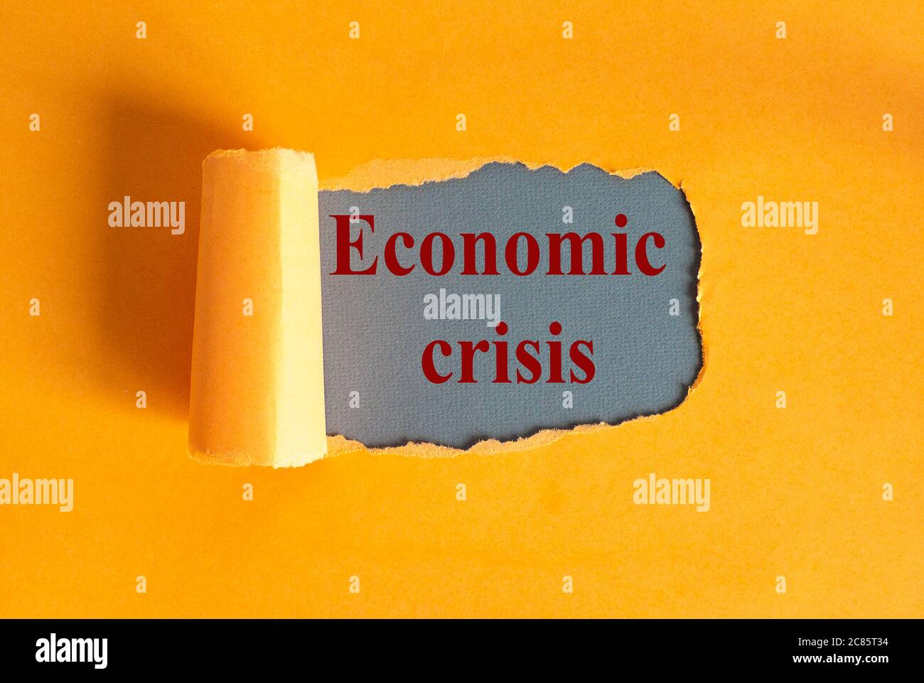 The text economic crisis appearing behind torn yellow paper Stock Photo ...