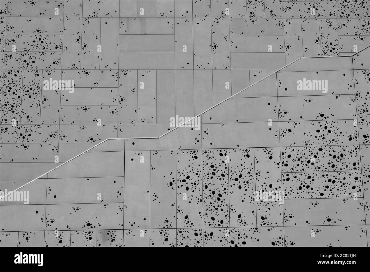 Grayscale shot of a building facade with lots of spots Stock Photo - Alamy