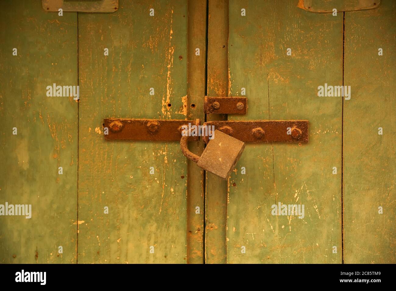 A vintage wooden door of a historic building locked by a rusty padlock Stock Photo - Alamy
