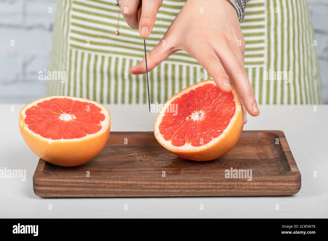 Cutting a grapefruit on a wooden board Stock Photo - Alamy