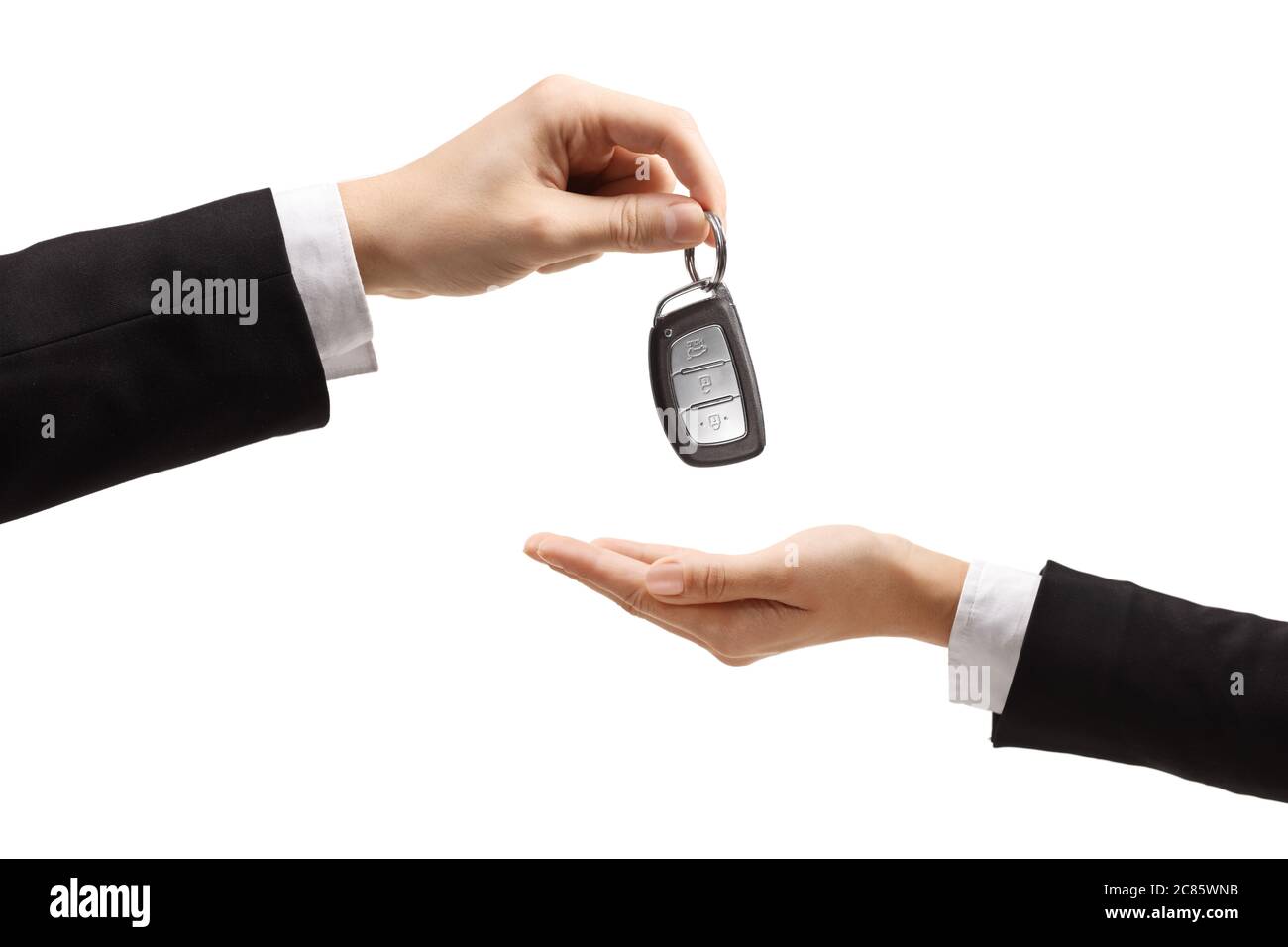 Male hand giving car keys to a female hand in a formal wear isolated on ...