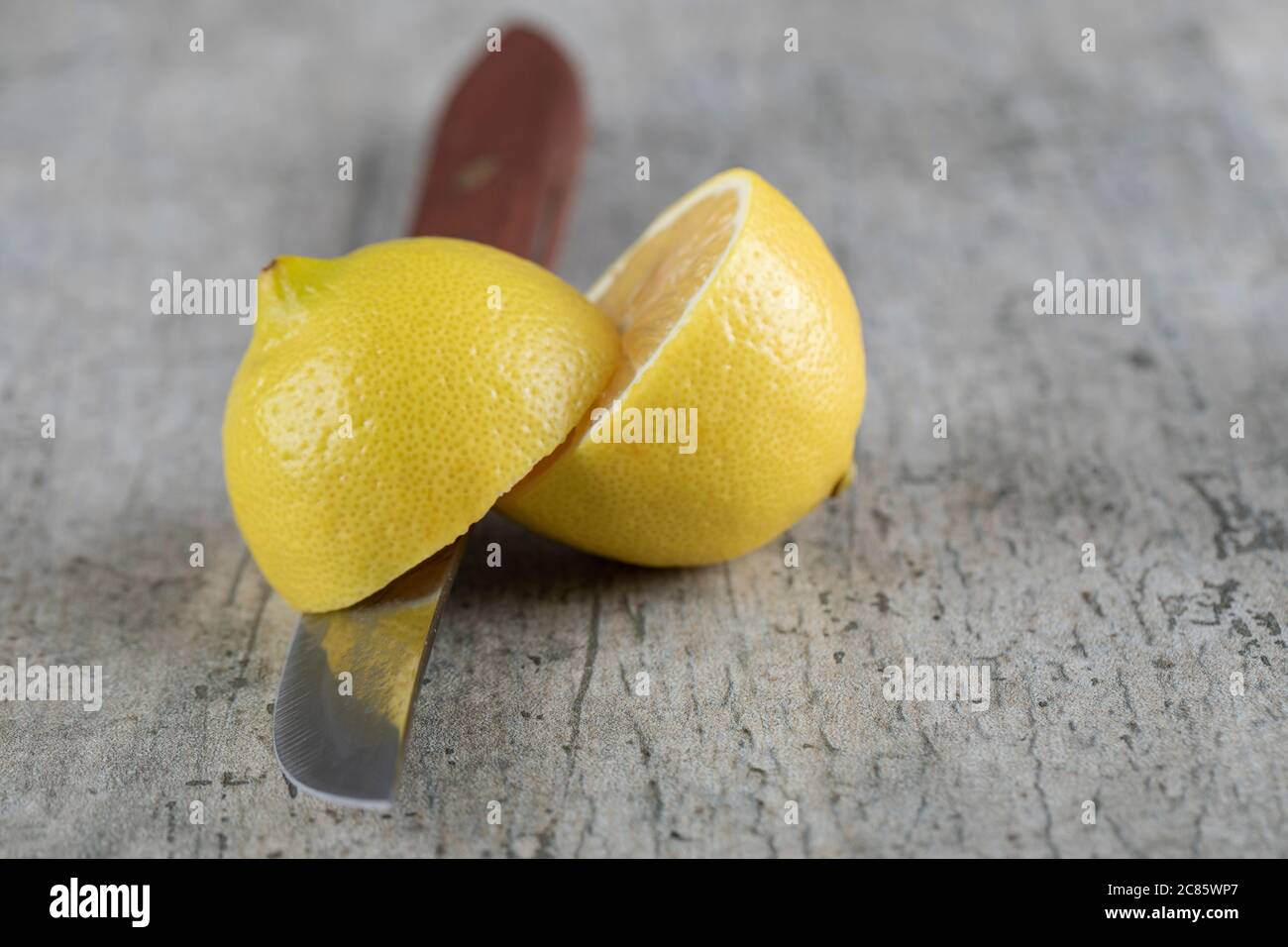 Lemon cut into half with a knife Stock Photo - Alamy