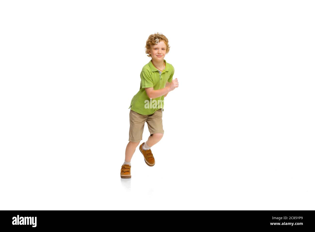 Happy child, little and emotional caucasian boy jumping and running ...