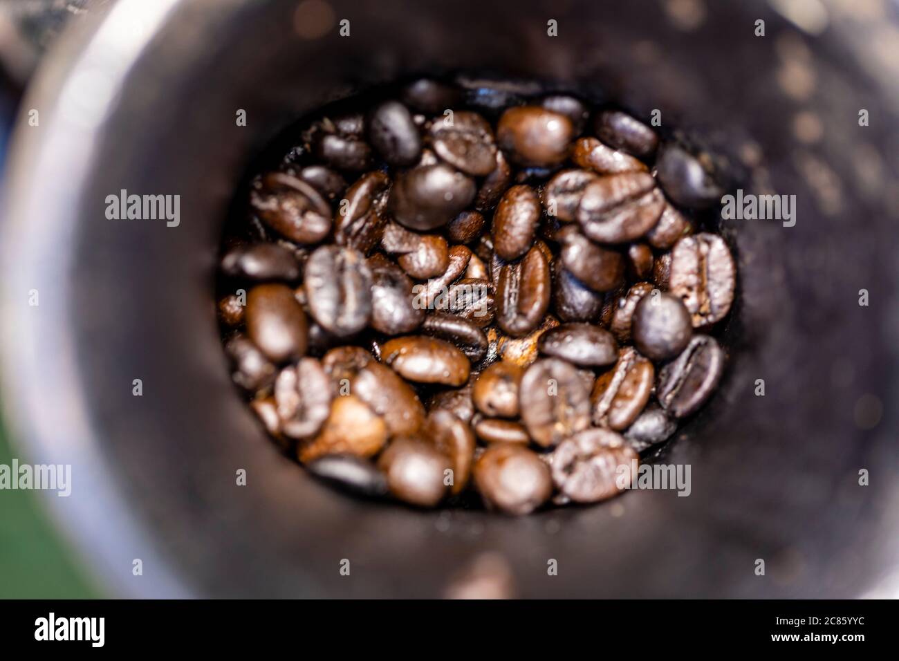 Roasted coffee beans inside in the manual grinder Stock Photo - Alamy