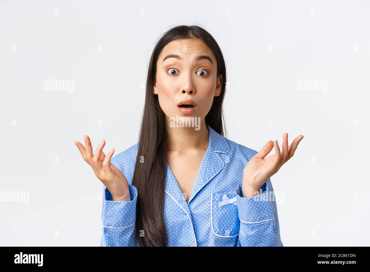Close-up of confused and shocked asian girl in blue pajama stare ...