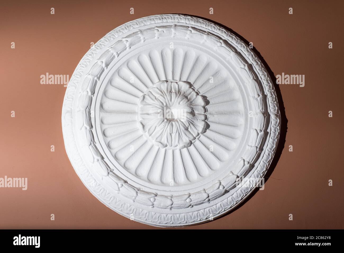 architectural decorative finish on a brown wall, white, round gypsum ...