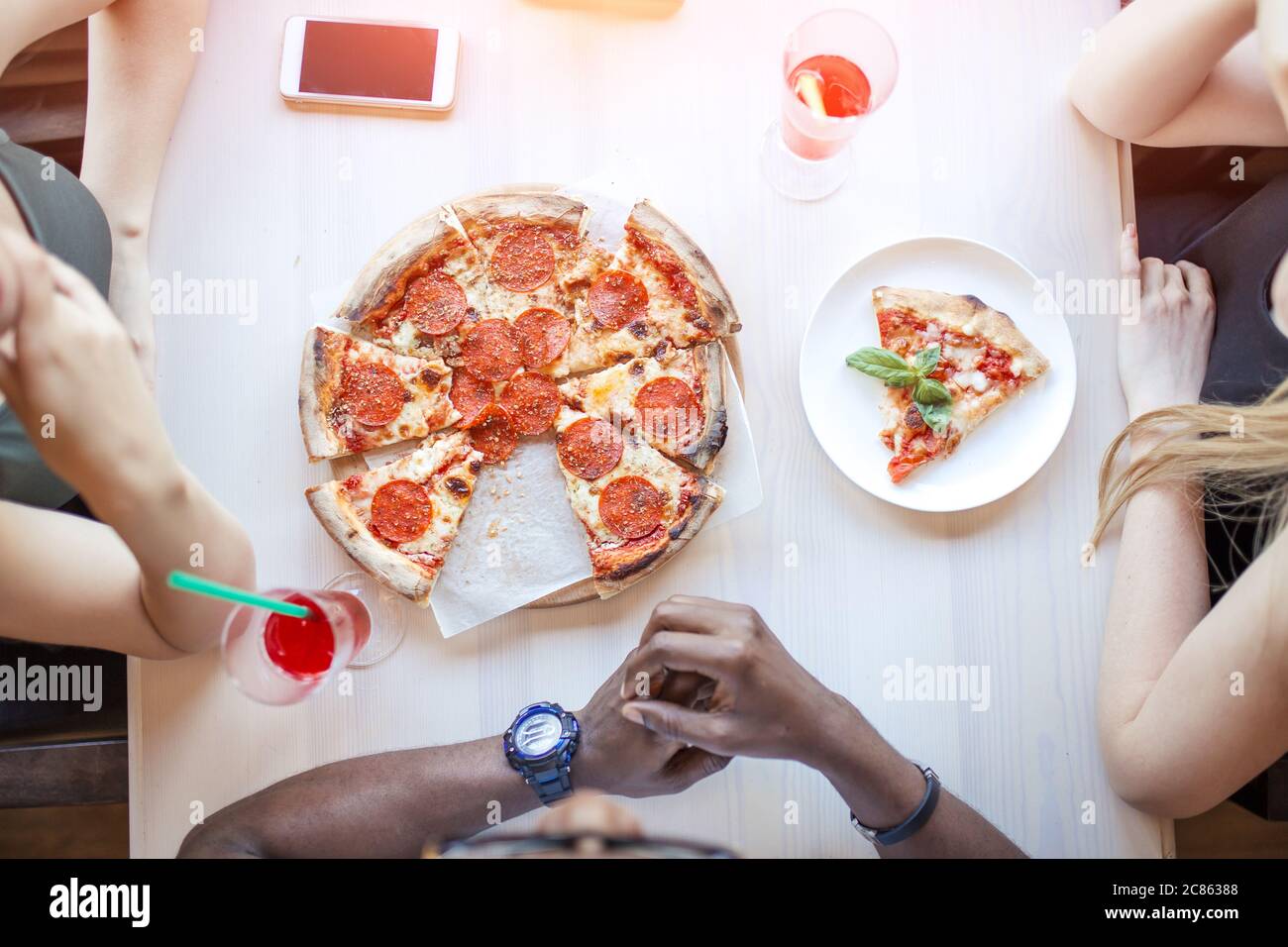 Lunch time at pizzeria, multiracial people grabbing huts of delicious ...
