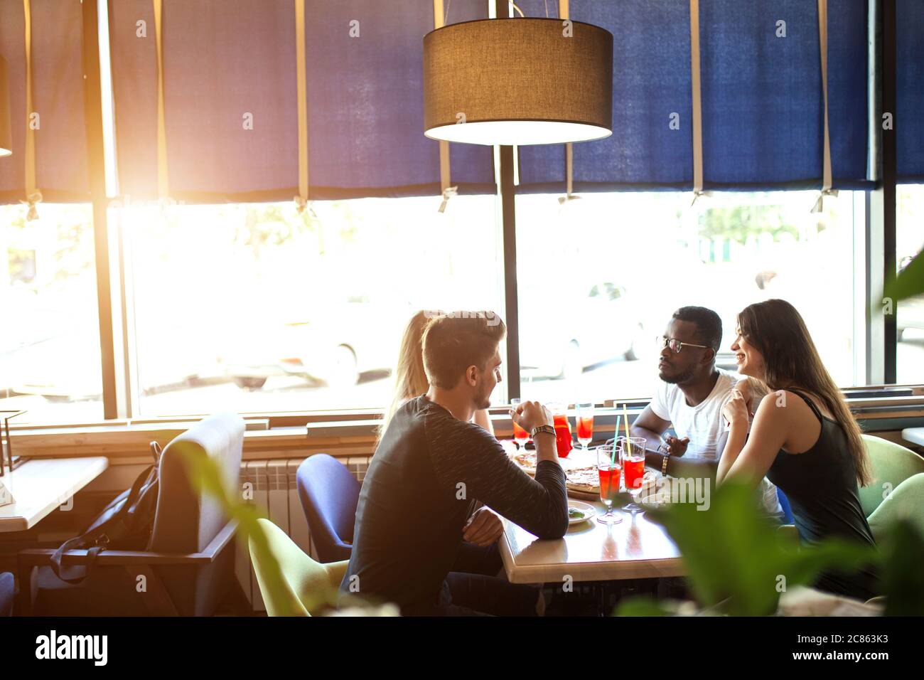 Hungry multiethnic male and female co-workers having lunch break ...