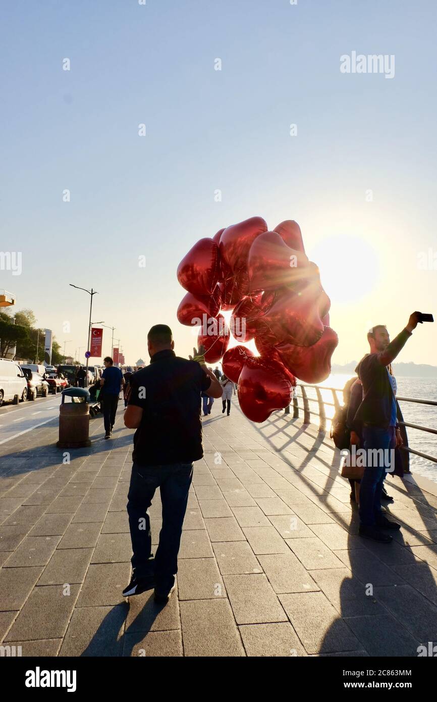 ISTANBUL, TURKEY - Nov 15, 2019: Red balloons in bridge, people sell ...