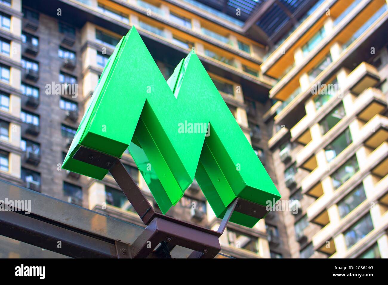 KYIV, UKRAINE - JULY 04, 2020: Green metro sign and modern building as ...